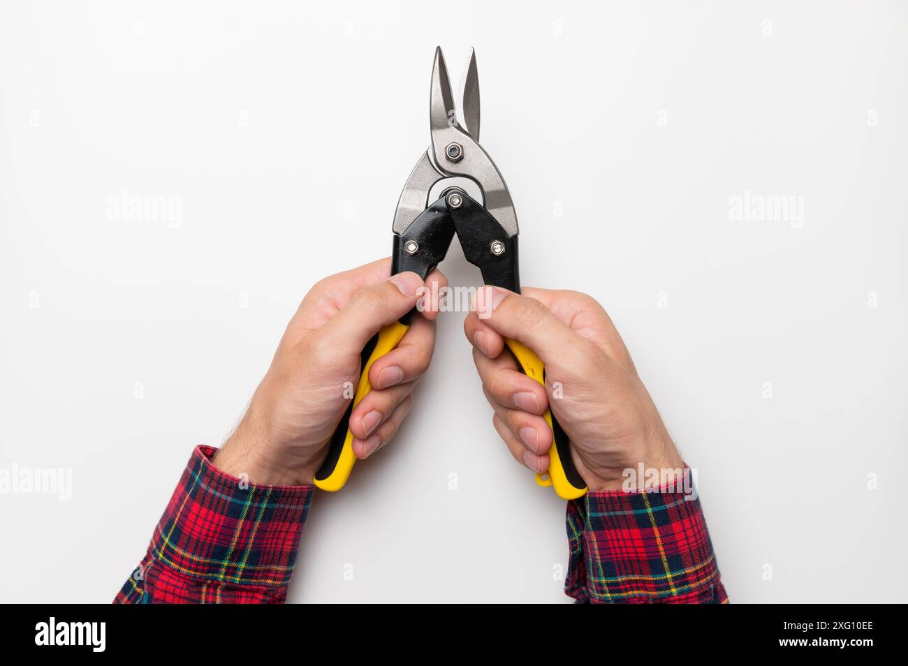 Male hands hold yellow bright tongs of a construction tool, on a white ...