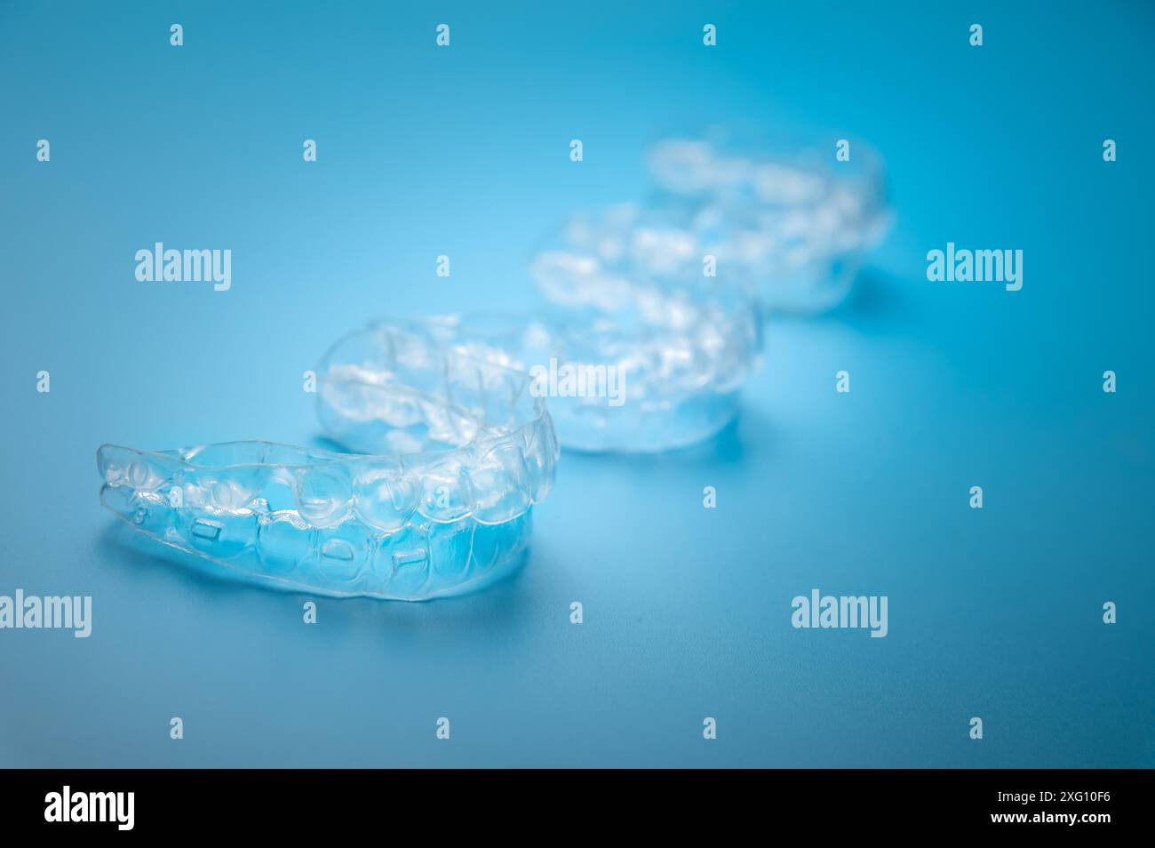 Invisible aligners on a blue background with copy space. Plastic braces ...