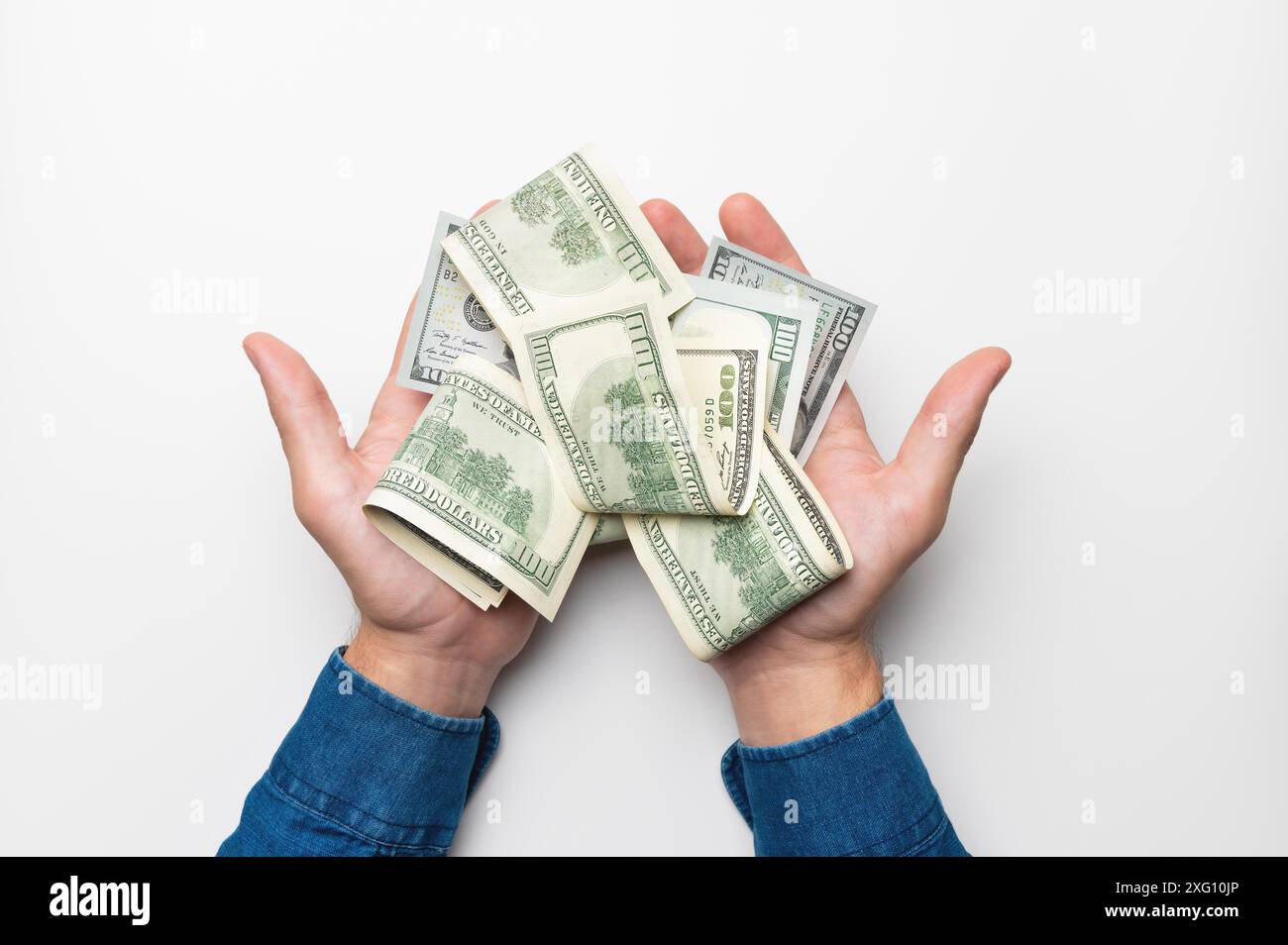 Men's hands hold out a bunch of folded money, dollar bills, repay a ...