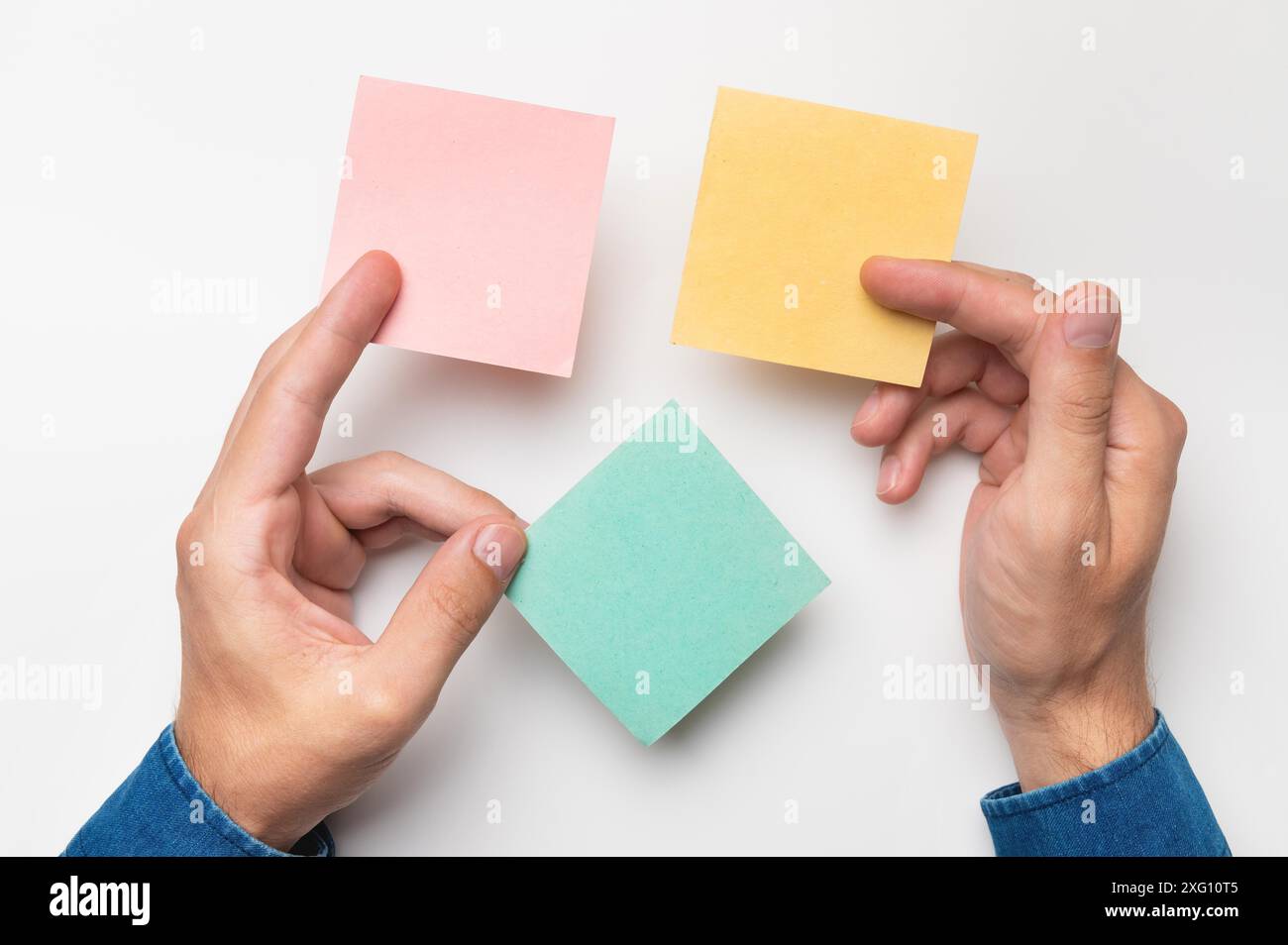 Hands of an office worker hold colored stickers for notes on a white ...