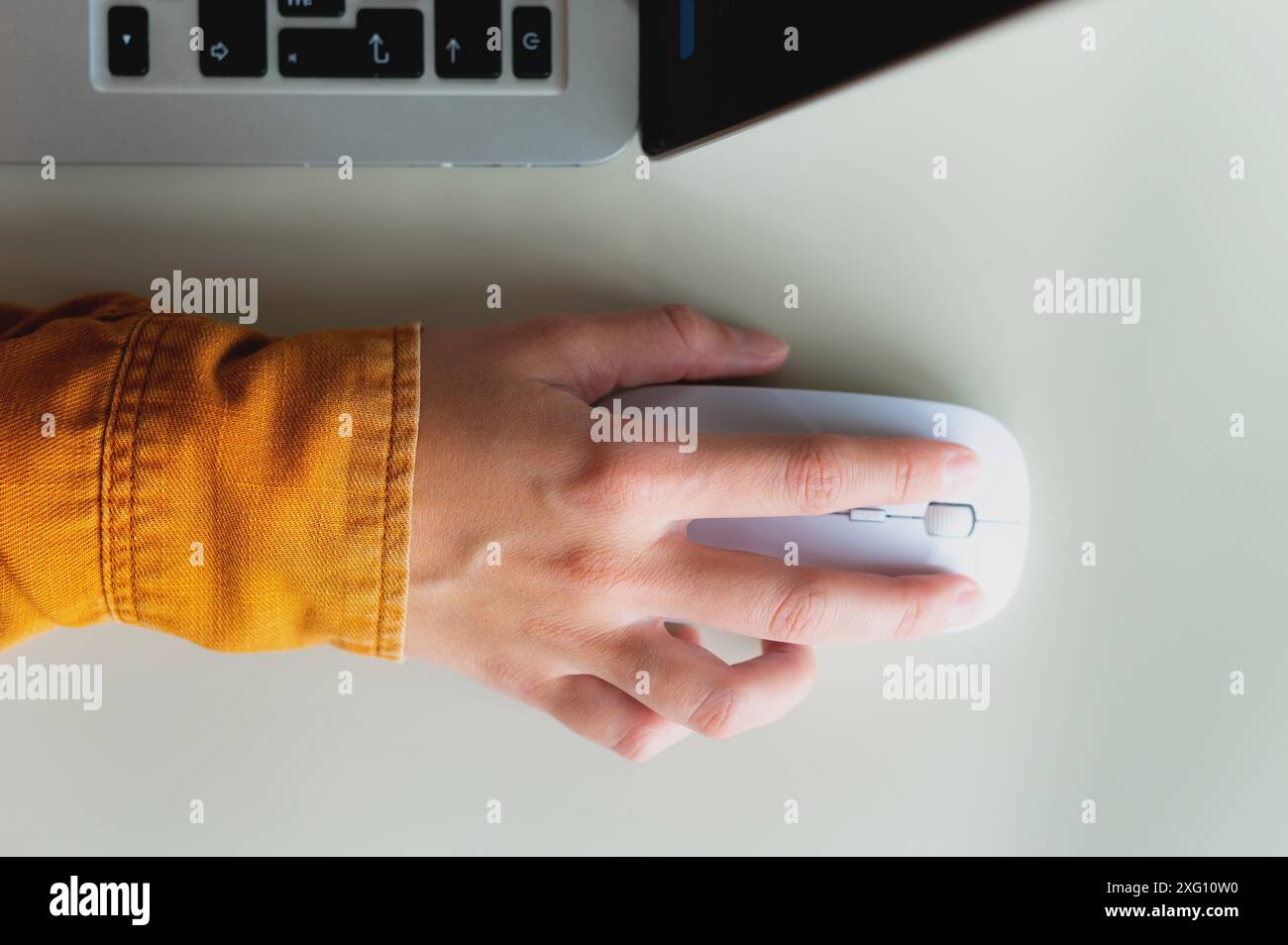 From above, close-up photo of a hand with a wireless white computer ...