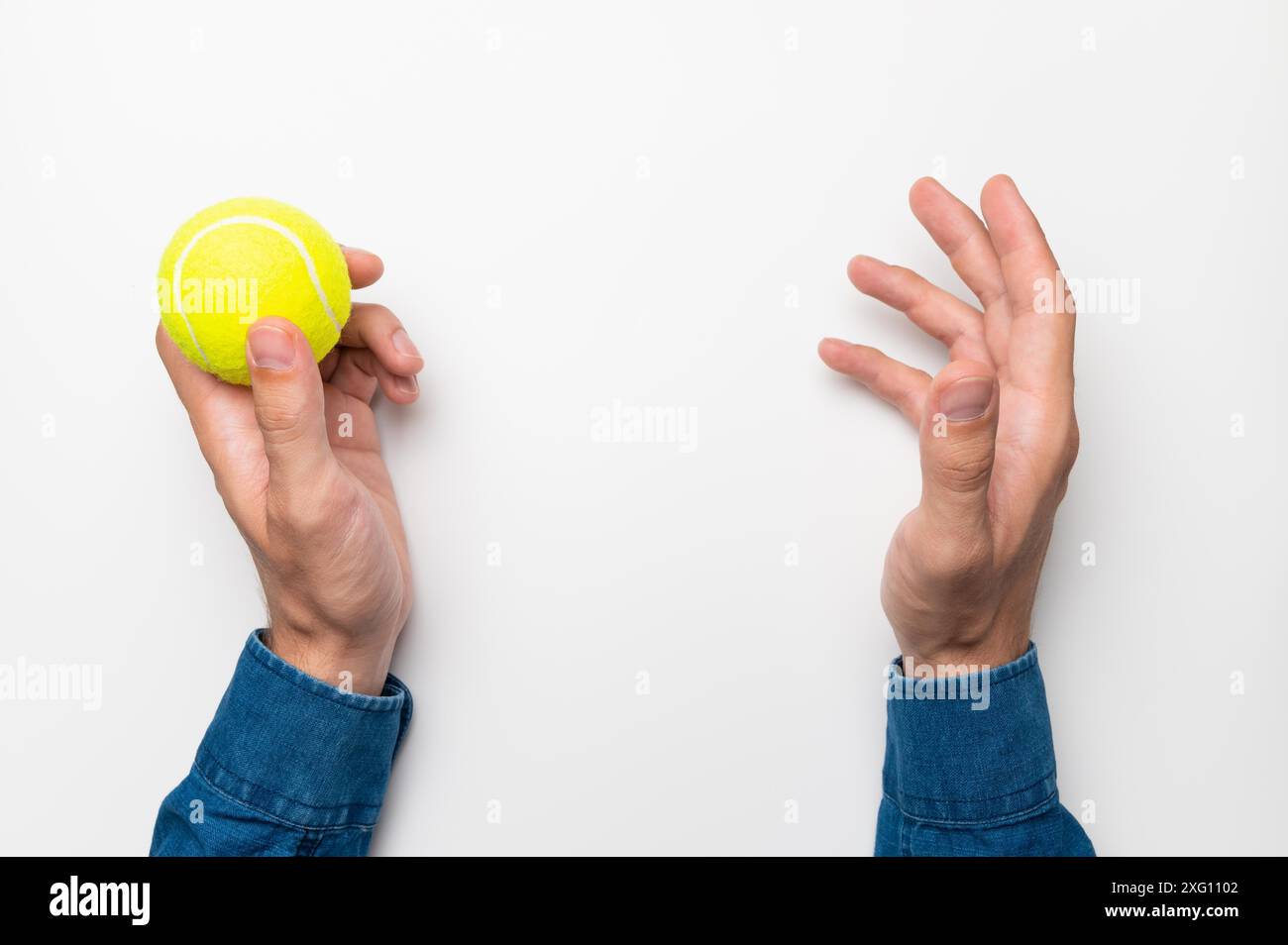 Yellow tennis ball in a male hand on a white background, a place for ...