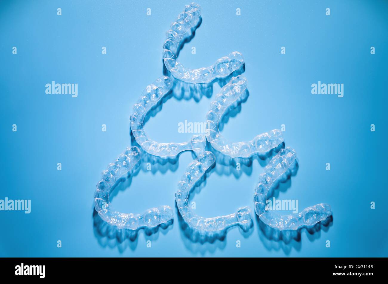 Close up, invisible aligners on a blue background in the shape of a ...
