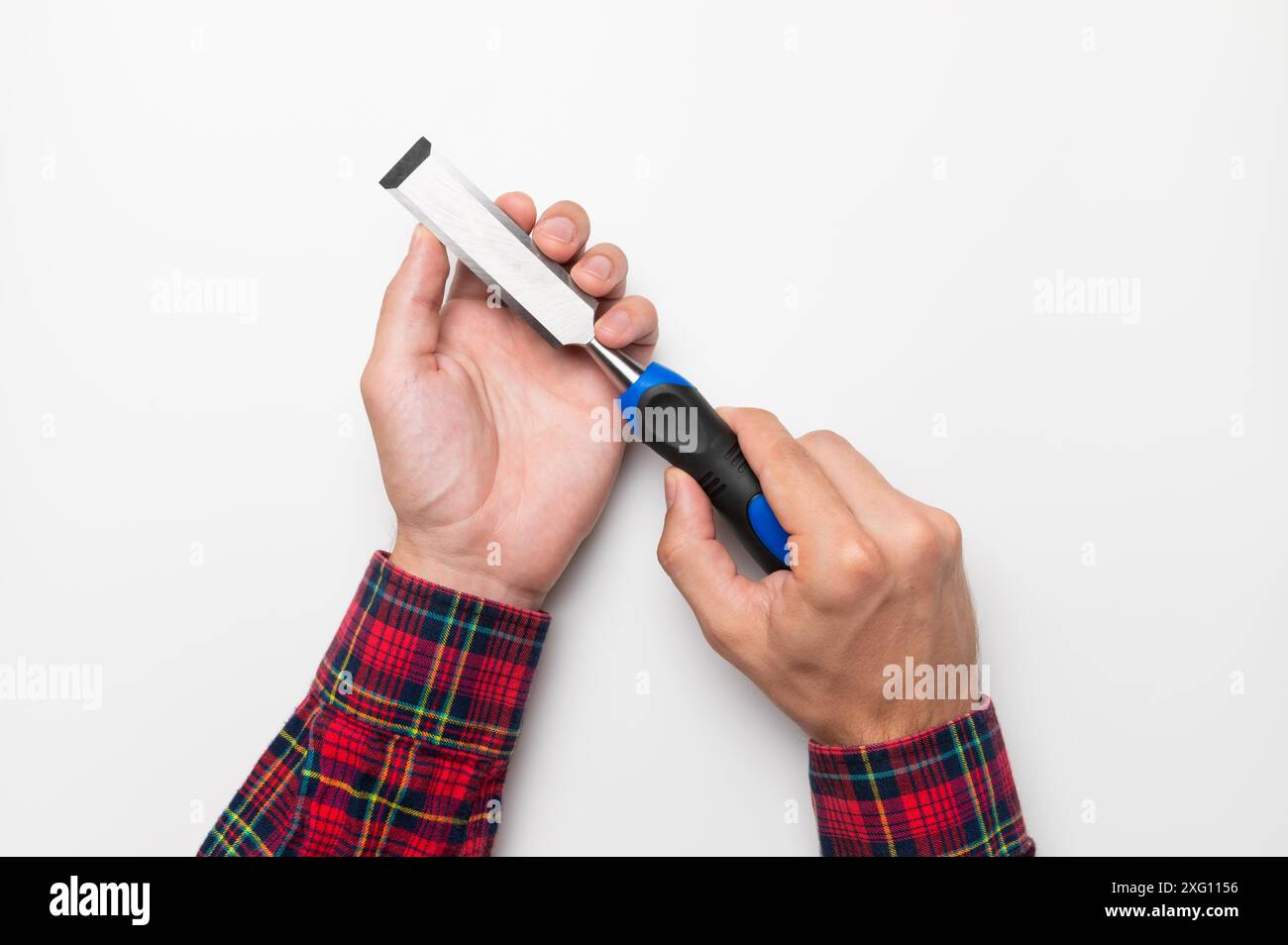 Hand tool chisel on a white background in a man's hand, top view ...