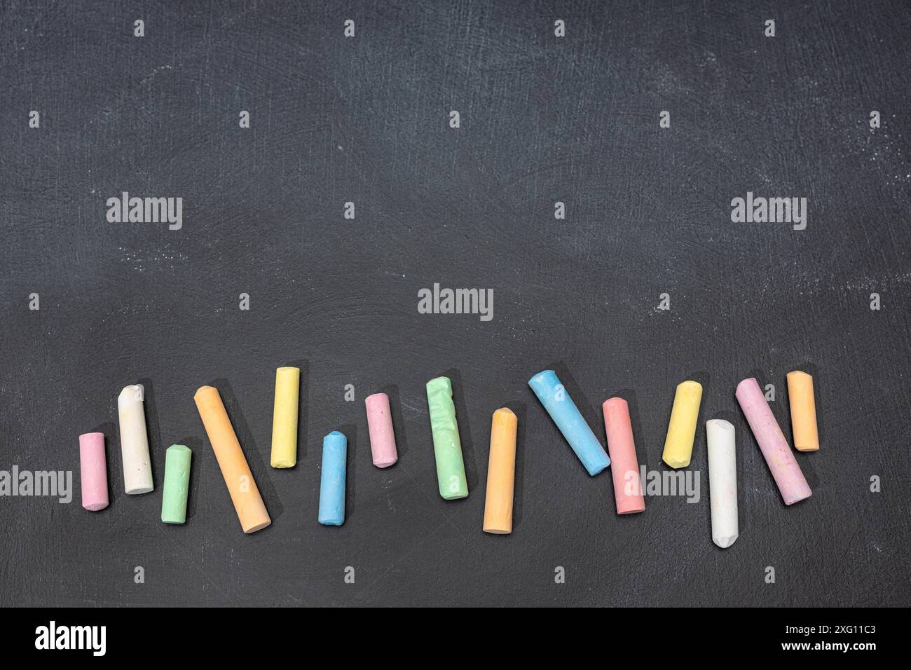 Variety of colored chalk sticks on blackboard. Copy space. Back to ...