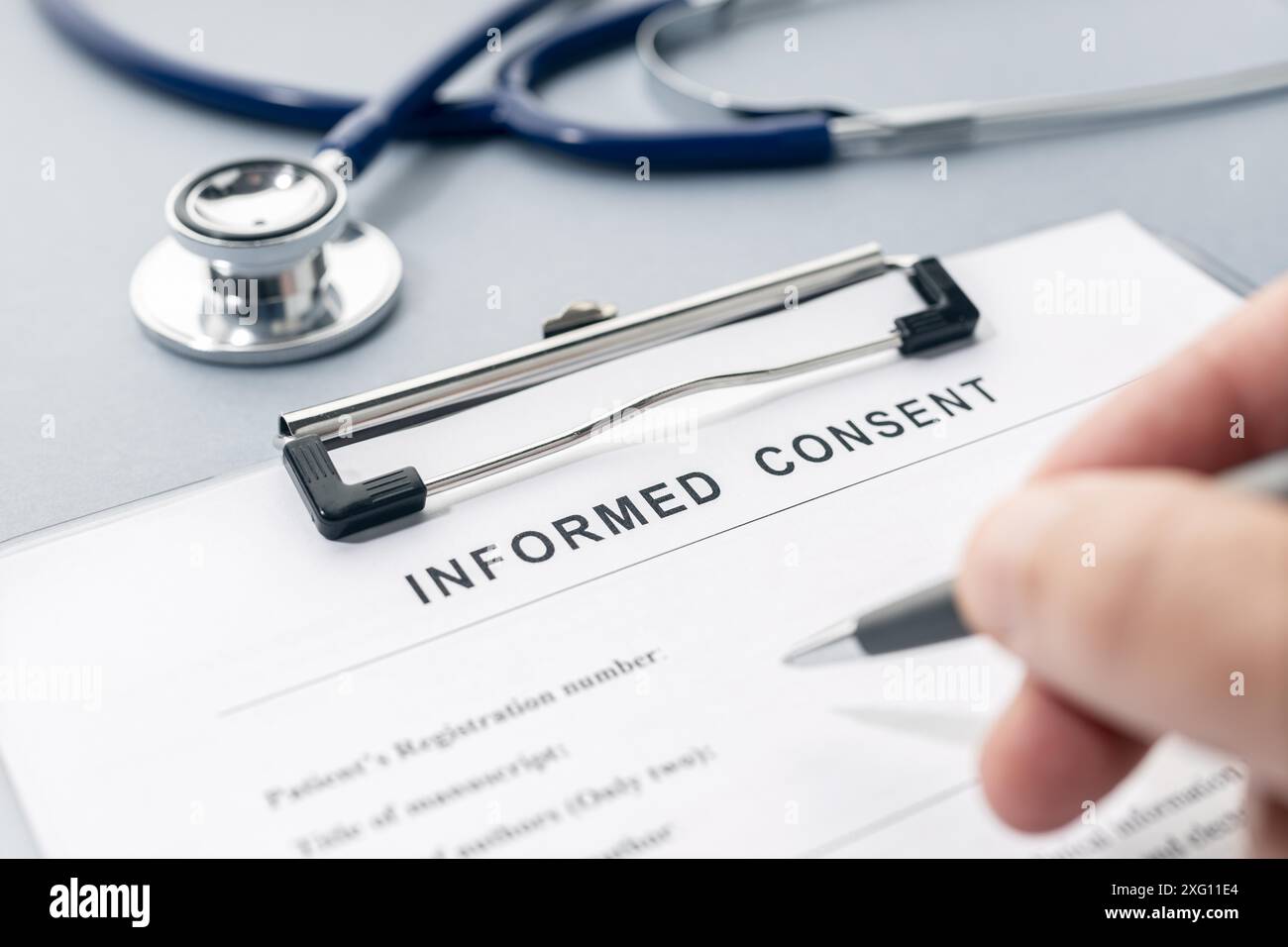Hand filling a Informed Consent form and stethoscope on desk Stock ...