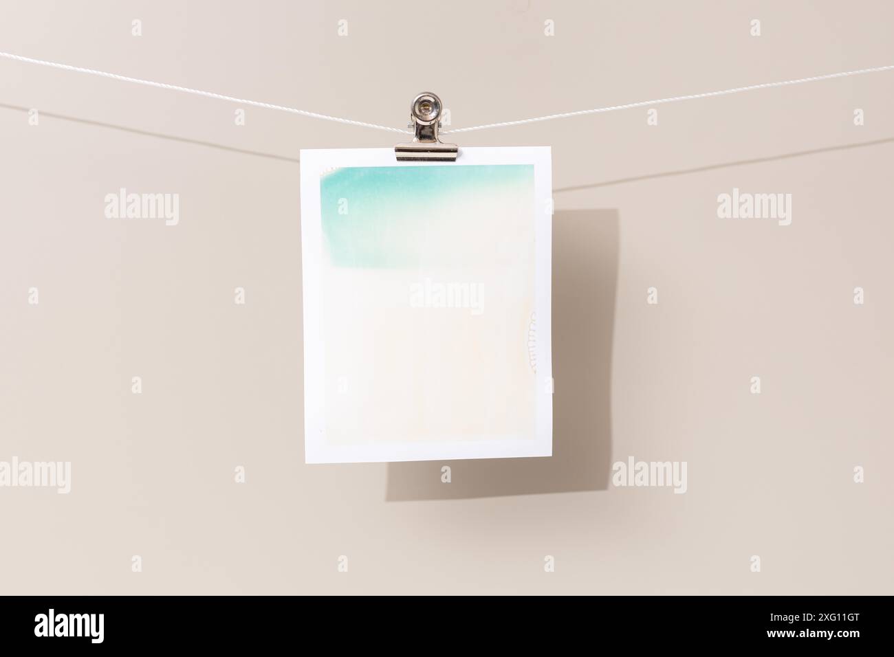 Instant photo frame with green and beige patches hanging on a rope ...