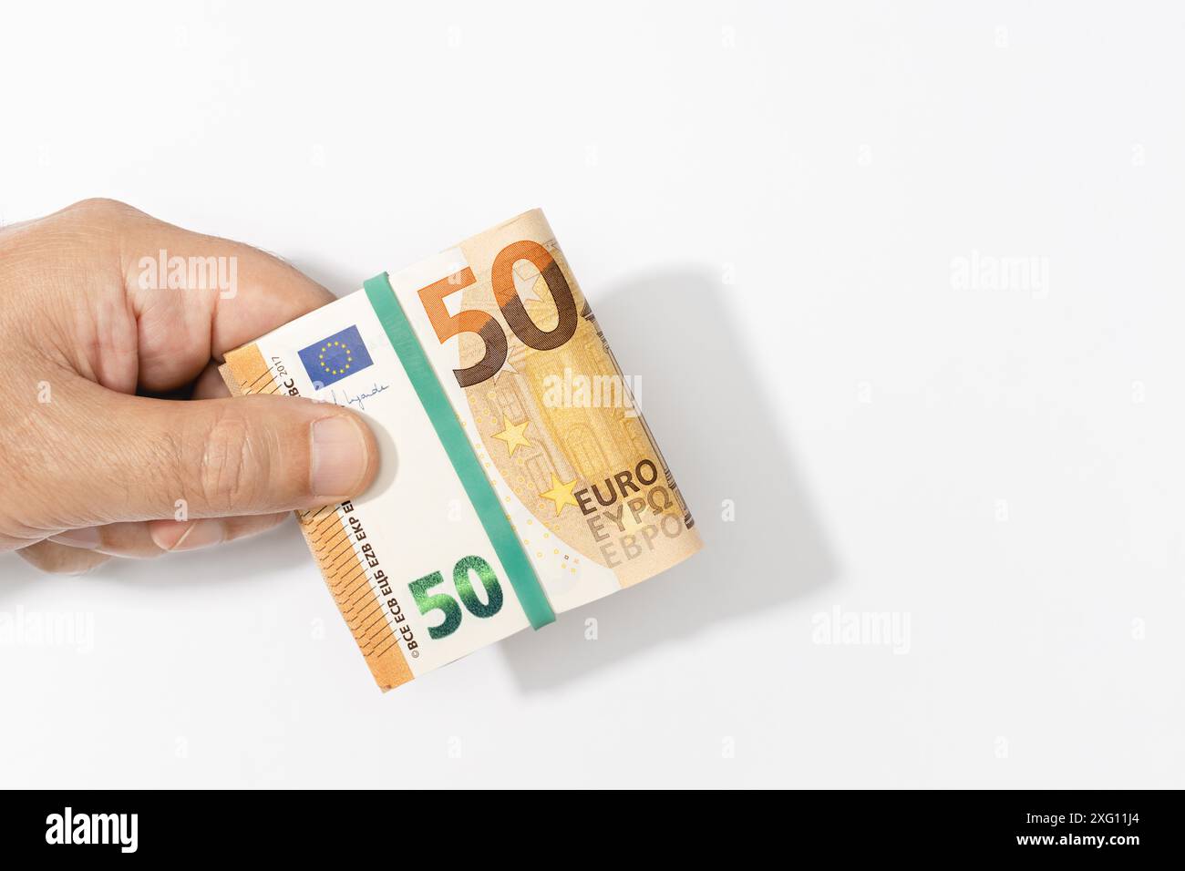 Hand holding a folded euro banknotes on white background. Copy space ...