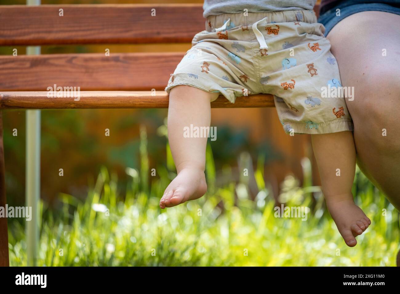Baby grow up concept: Close up of barefoot baby feet sitting on park ...