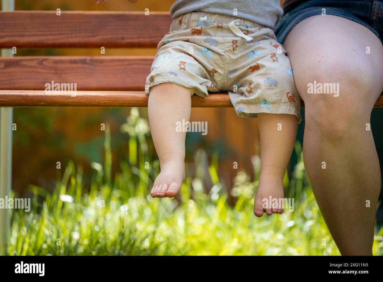 Baby grow up concept: Close up of barefoot baby feet sitting on park ...