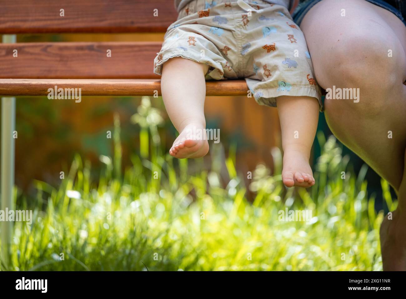 Baby grow up concept: Close up of barefoot baby feet sitting on park ...