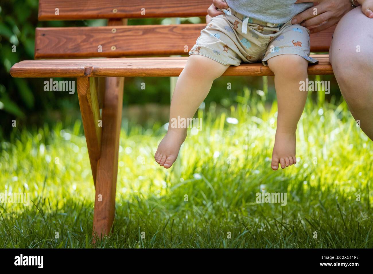 Baby grow up concept: Close up of barefoot baby feet sitting on park ...