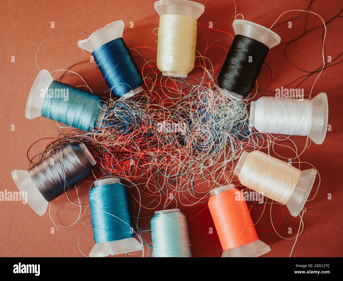 Spools of colored embroidery threads. Huge knot is haphazardly braided ...