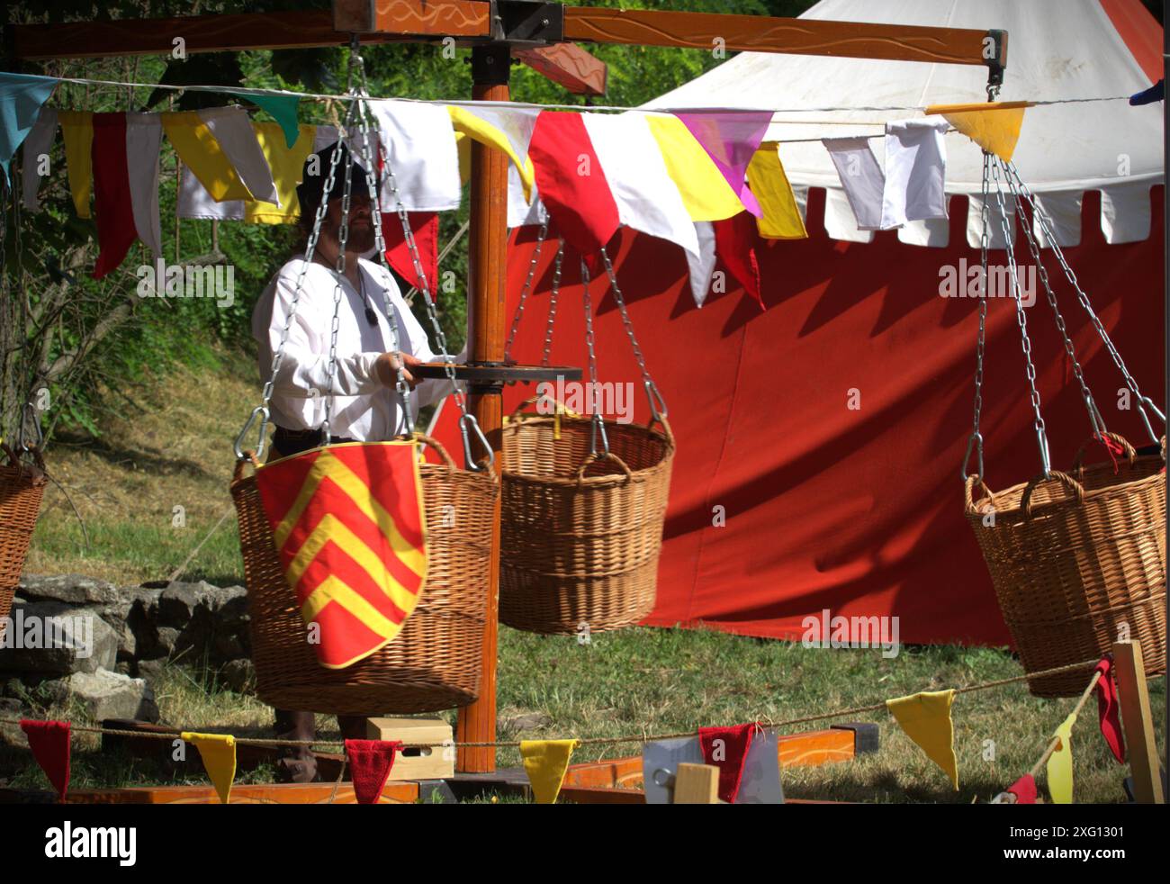Man in historical costume handling medieval basket carousel for kids ...