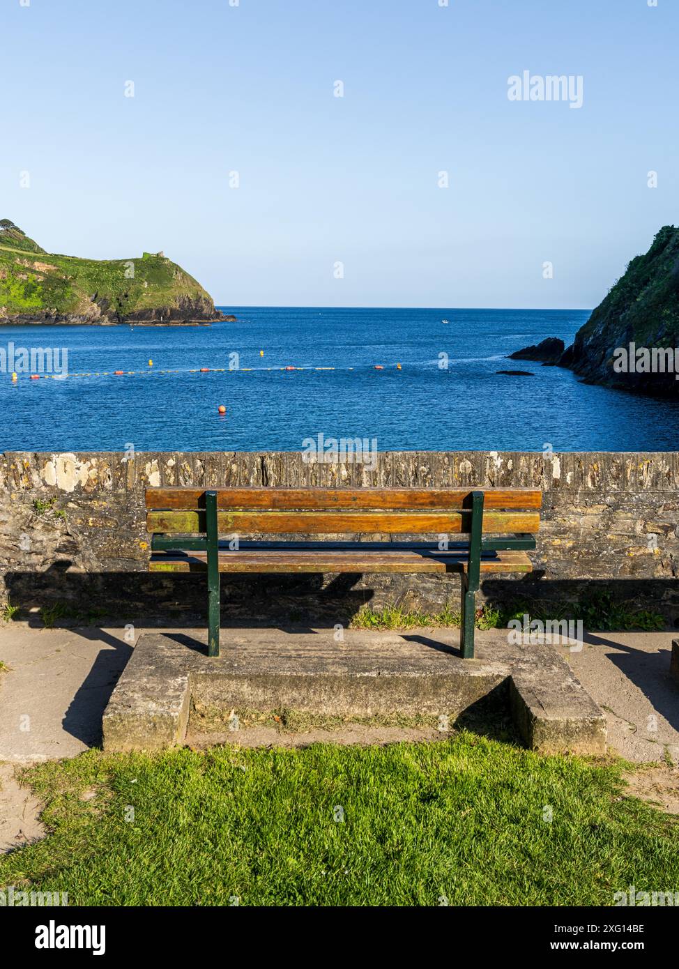 Bench on the beach at Readymoney Cove with a view across the river ...