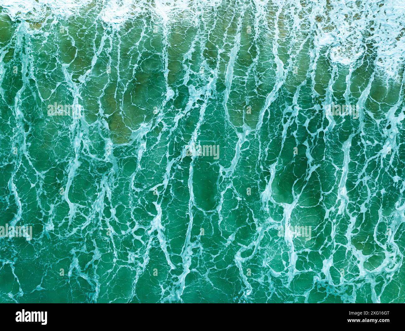 Overhead view turquoise stormy ocean waves with white foam in the ocean ...
