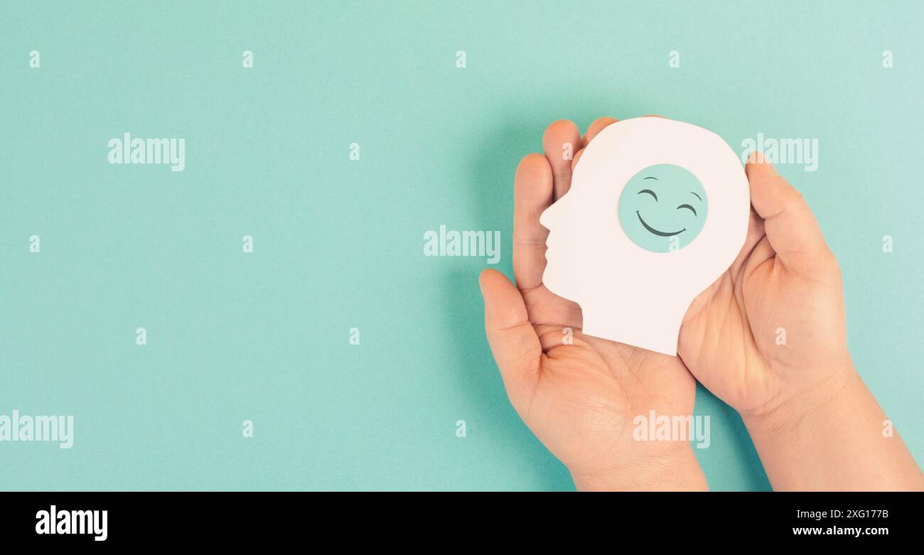 Holding a head with a smiling face in the hands, mental health concept ...