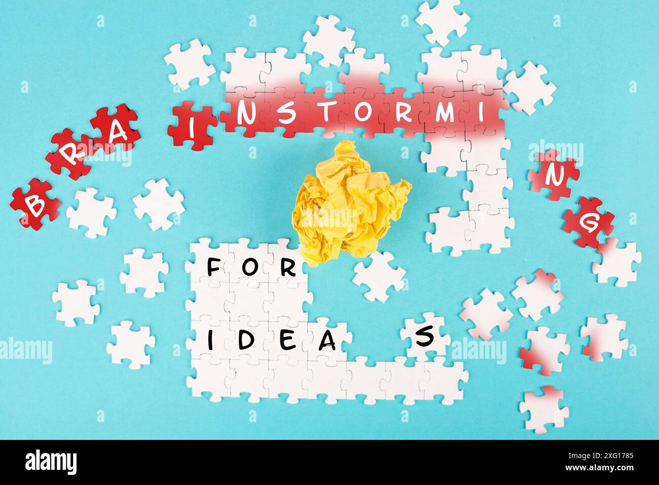 Puzzle on a blue background, yellow crumpled paper, words brainstorming ...