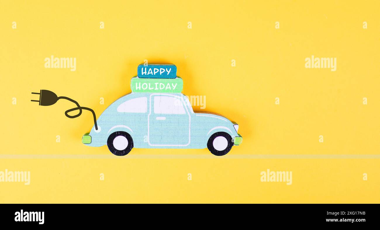 Small blue electric car with a cable for recharging, vacation trip with ...