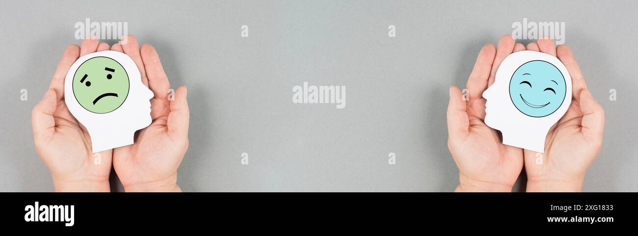 Holding a head with a sad and a happy face in the hands, mental health ...