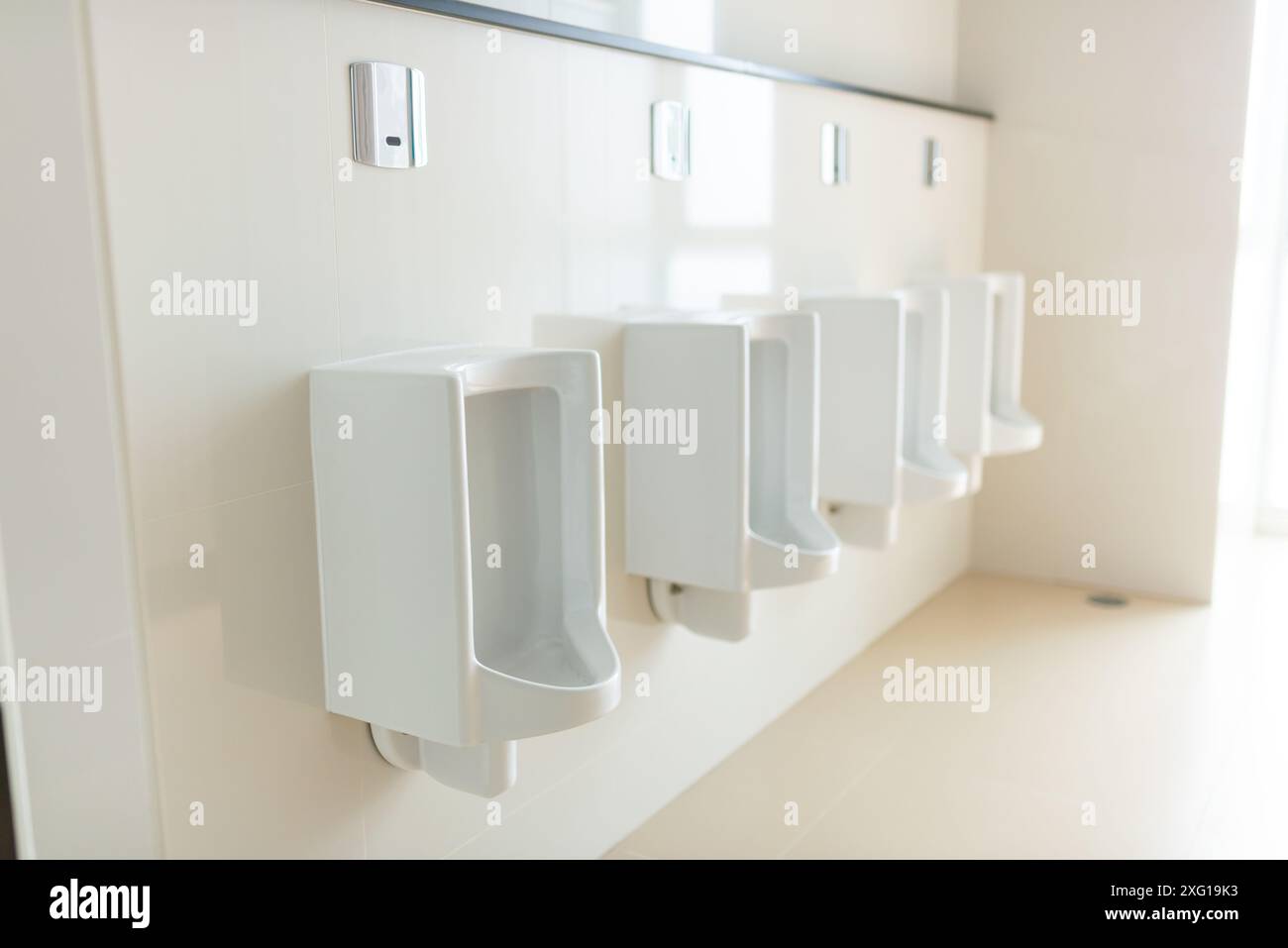 White urinals in the men's bathroom with tiled wall Stock Photo - Alamy