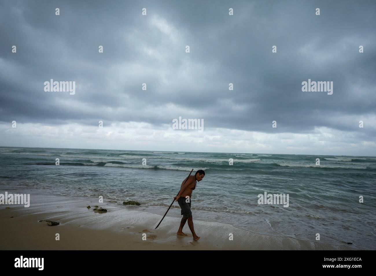 A man practices acrobatics with a pole on the beach in the aftermath by ...