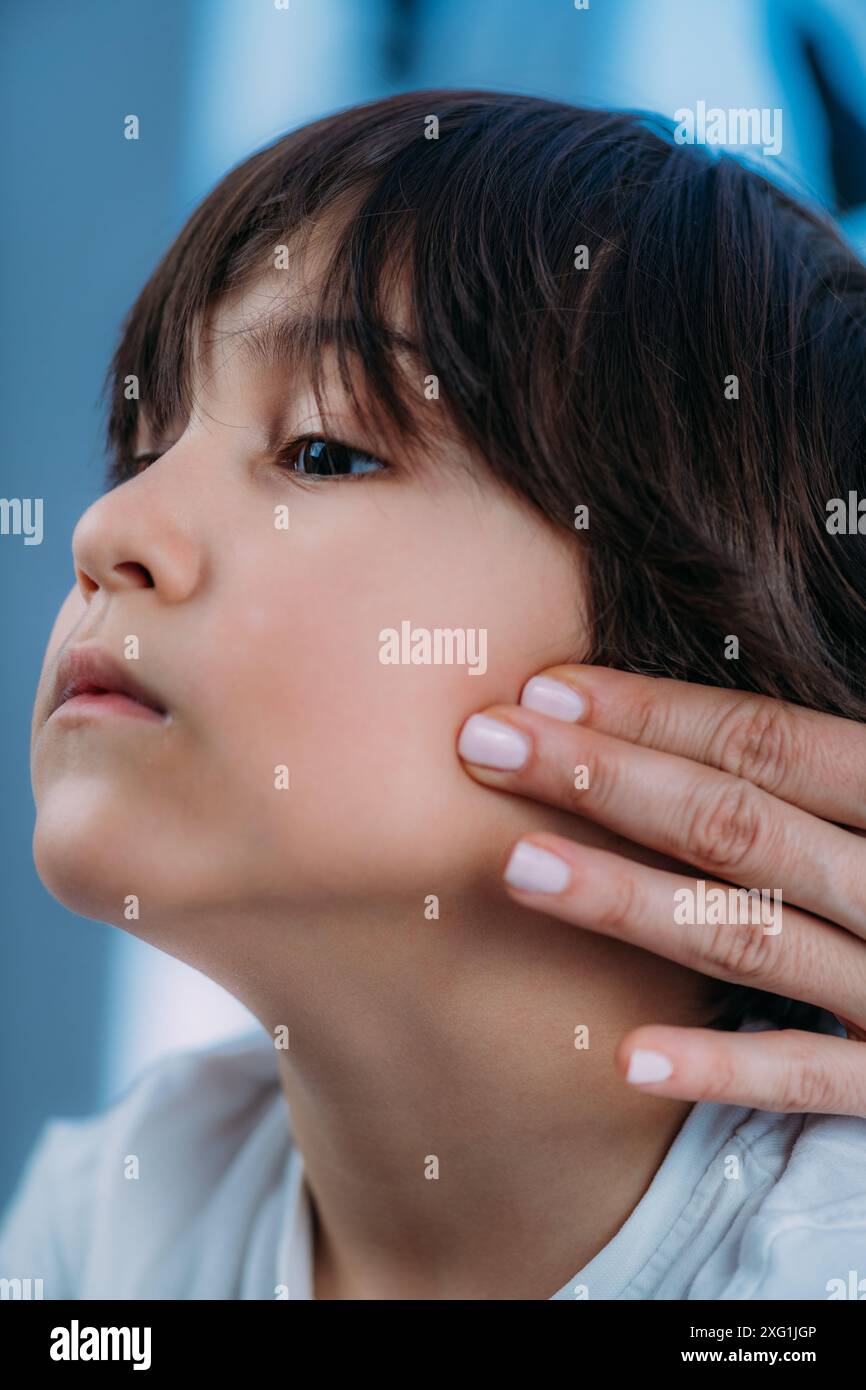 Paediatric endocrinologist , examining swollen lymph nodes of a young ...