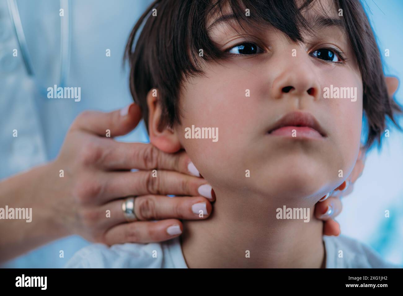 Paediatric endocrinologist , examining swollen lymph nodes of a young ...