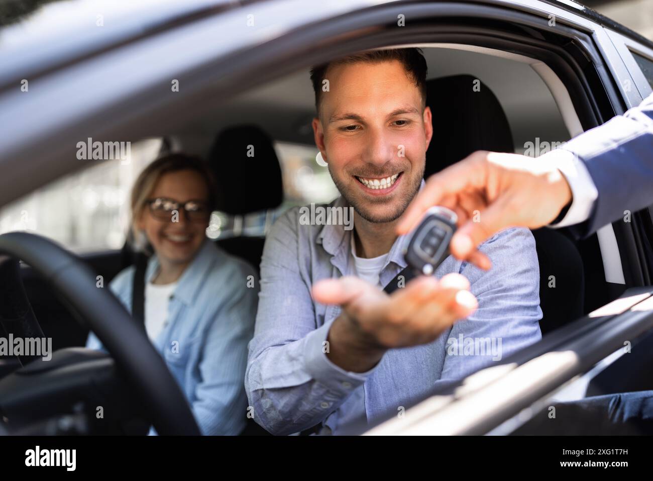 Smiling Hispanic Salesman Successfully Handing Over Keys to New Car ...