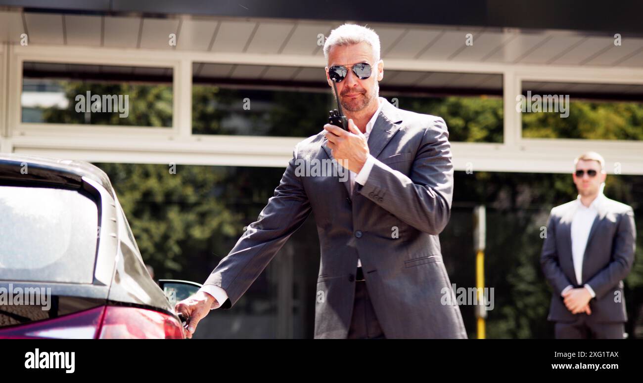 Professional bodyguards opening luxury car door for mature businessman ...