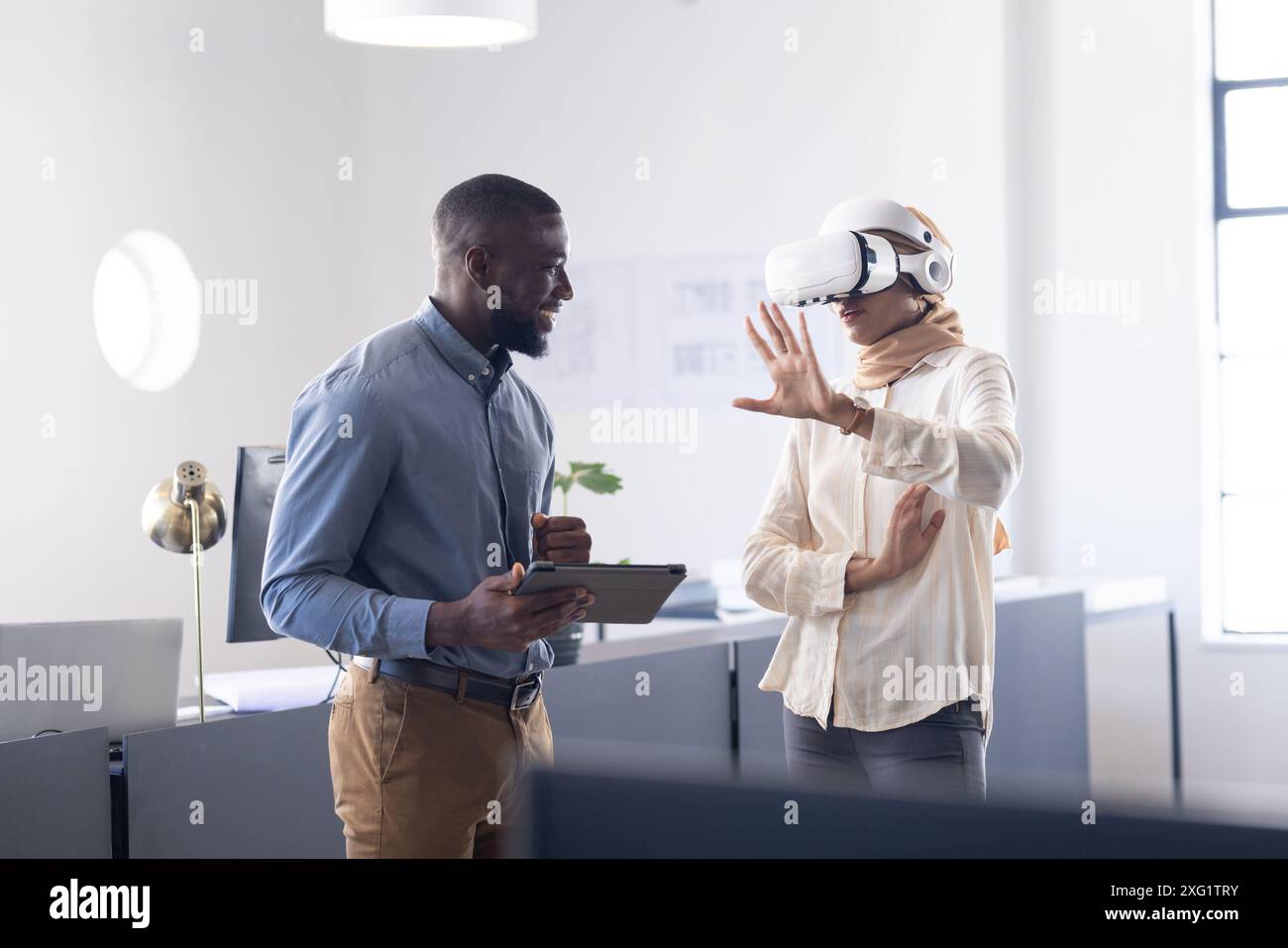 Using VR headset, woman interacting with virtual environment, colleague ...