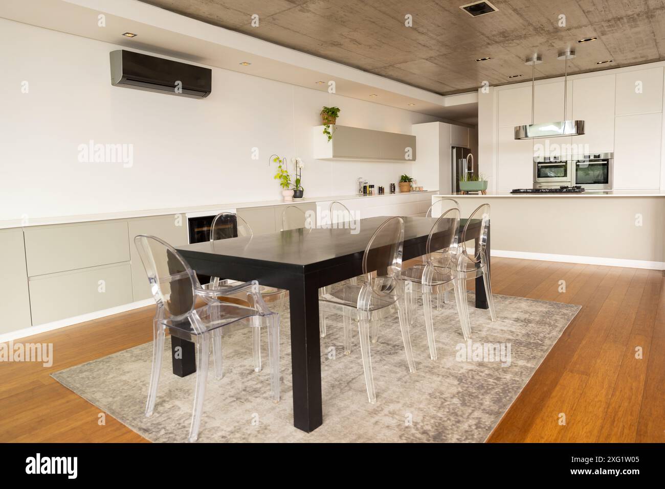 Modern kitchen with sleek design, transparent chairs, and large dining ...