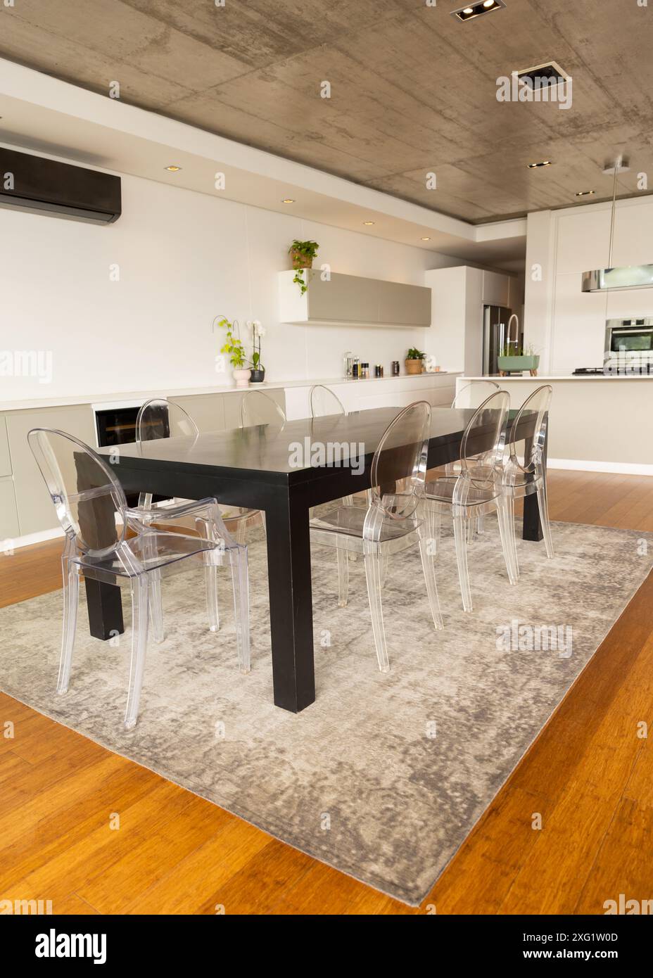 Chairs around table on rug in spacious dining room at home Stock Photo ...