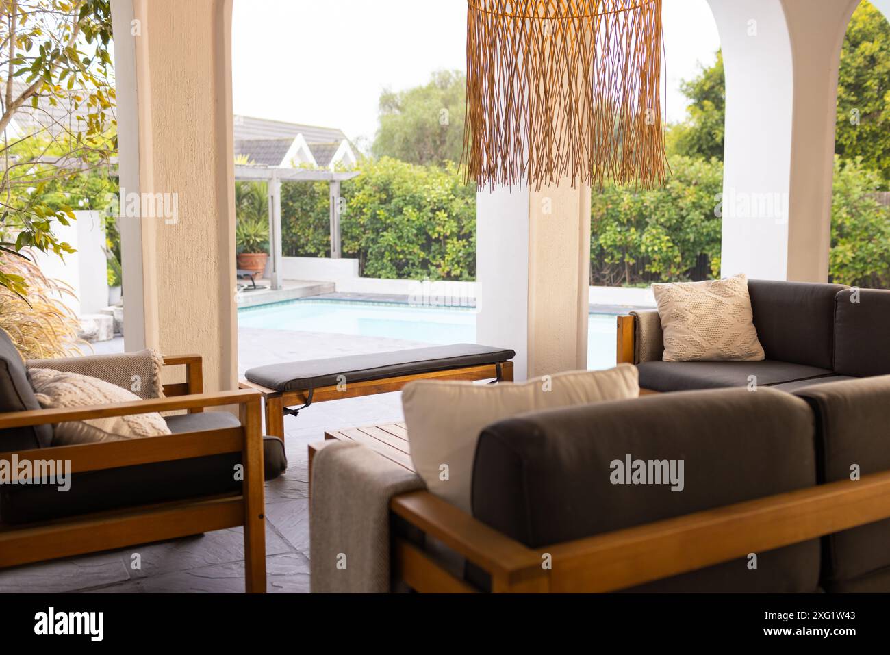 Outdoor patio with modern furniture overlooking swimming pool in ...