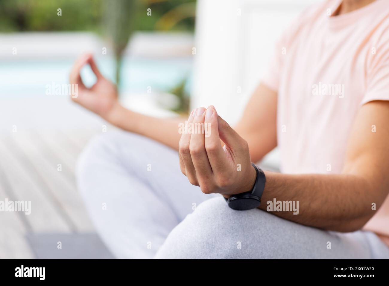 Practicing mindfulness, man sitting cross-legged and meditating ...