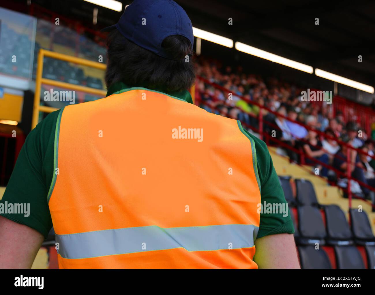 Man in fluorescent reflective vest during crowd control on the stands ...
