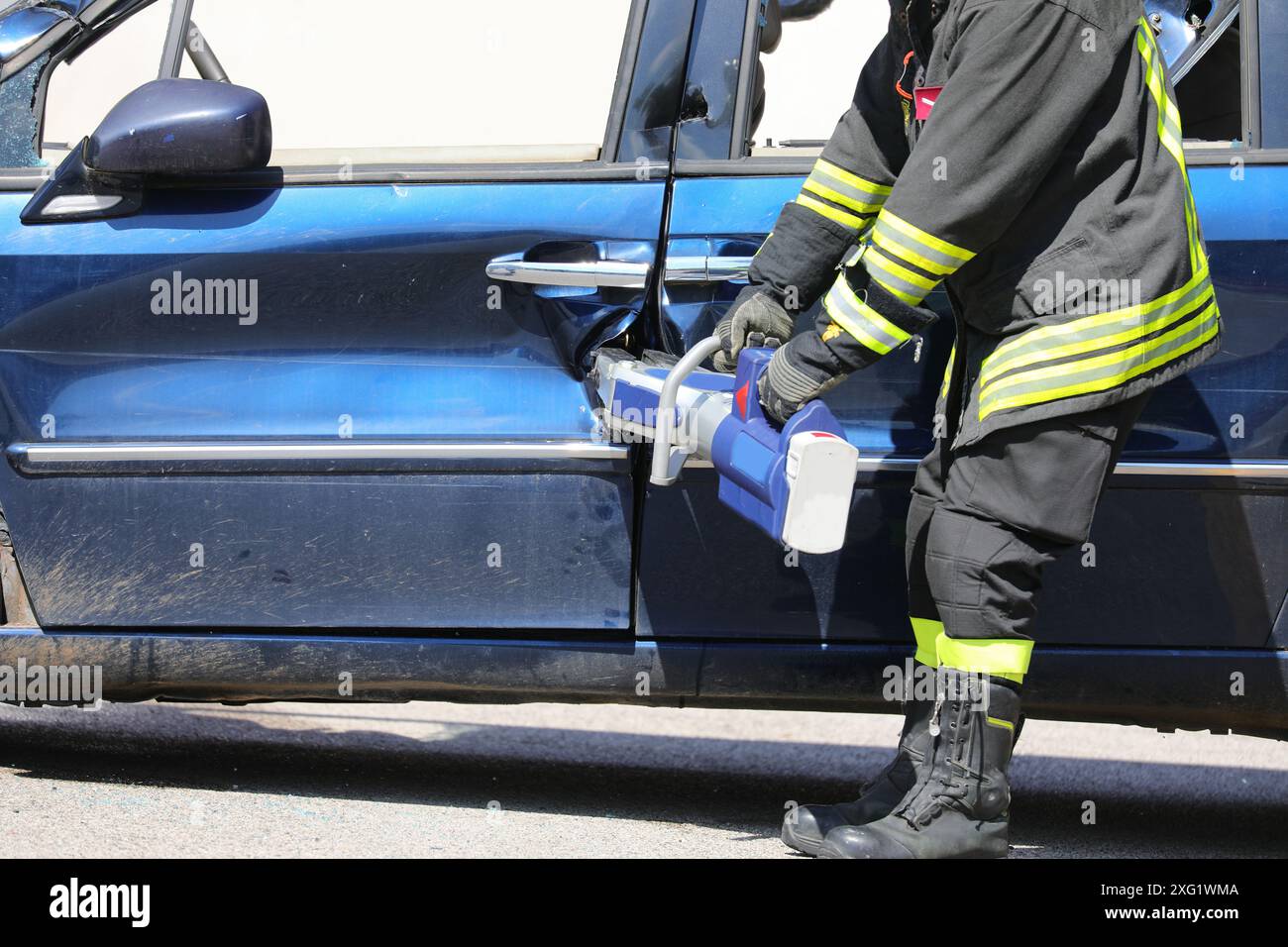 Firefighter using hydraulic tool called JAWS OF LIFE to pry open car ...