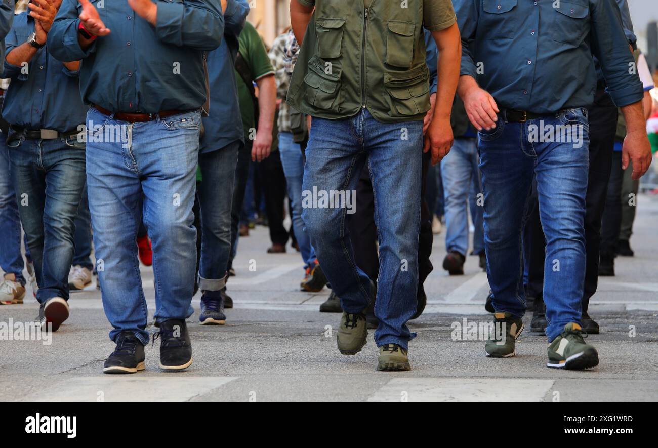 multitude of men strolling down city streets their legs clad in blue ...