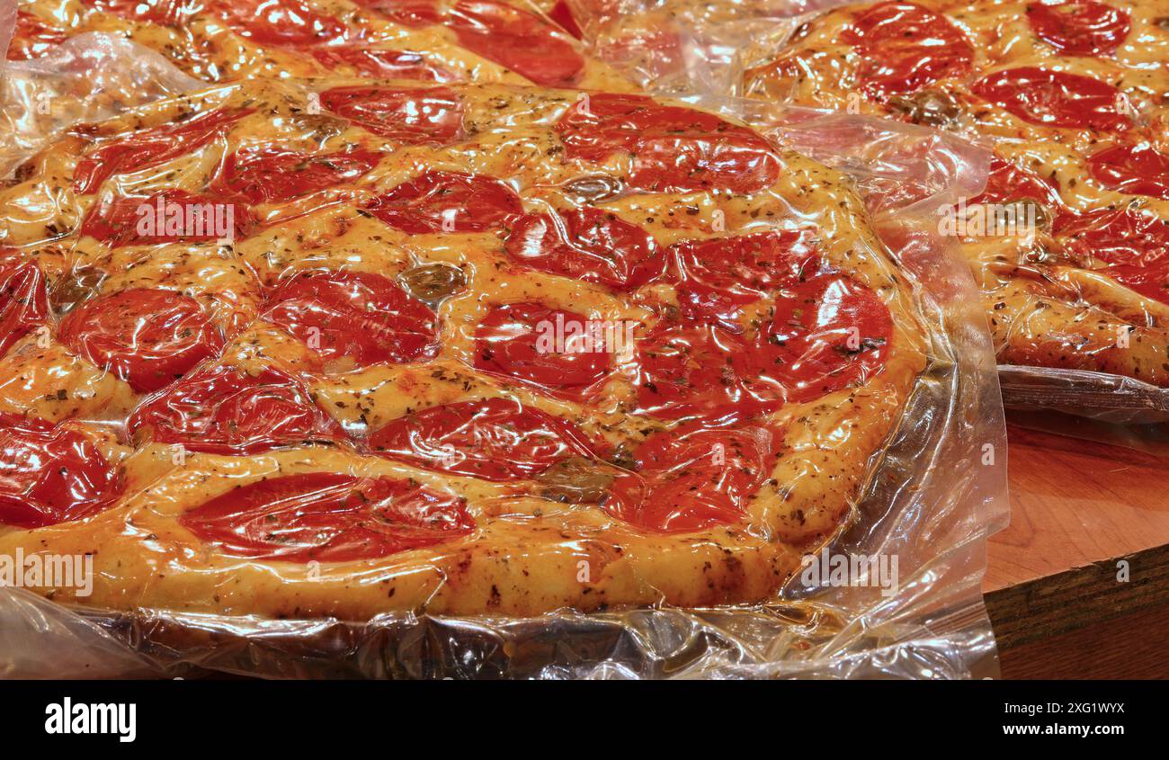 Neapolitan pizza with cheese and red tomatoes vacuum packed with an ...