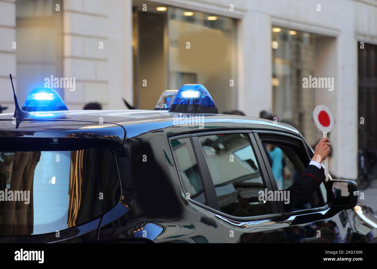 Police car with blue lights flashing and officer using siren during a ...