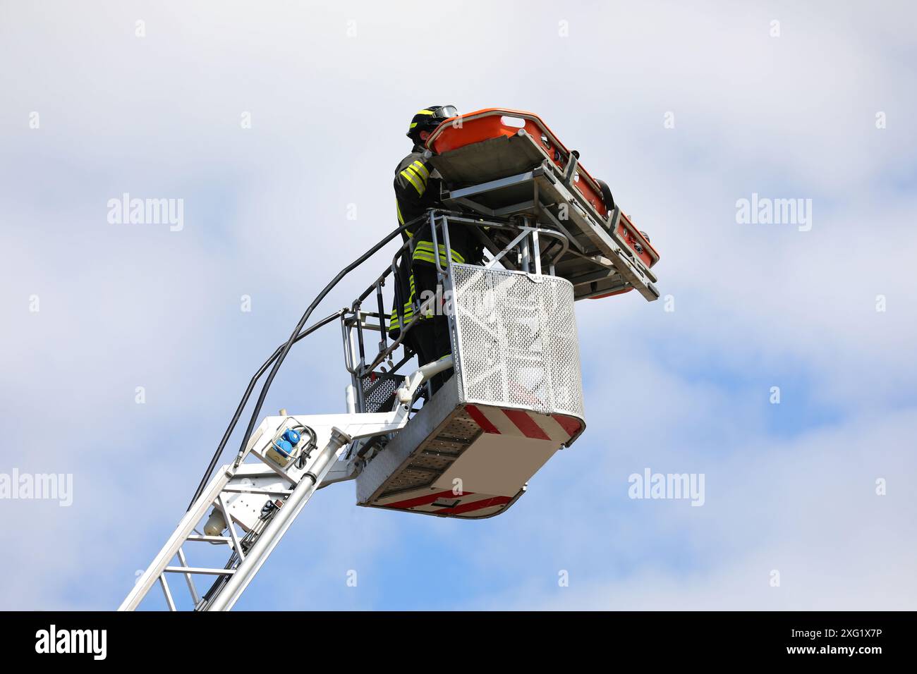 Firefighters on board an aerial platform crane with suspended stretcher ...
