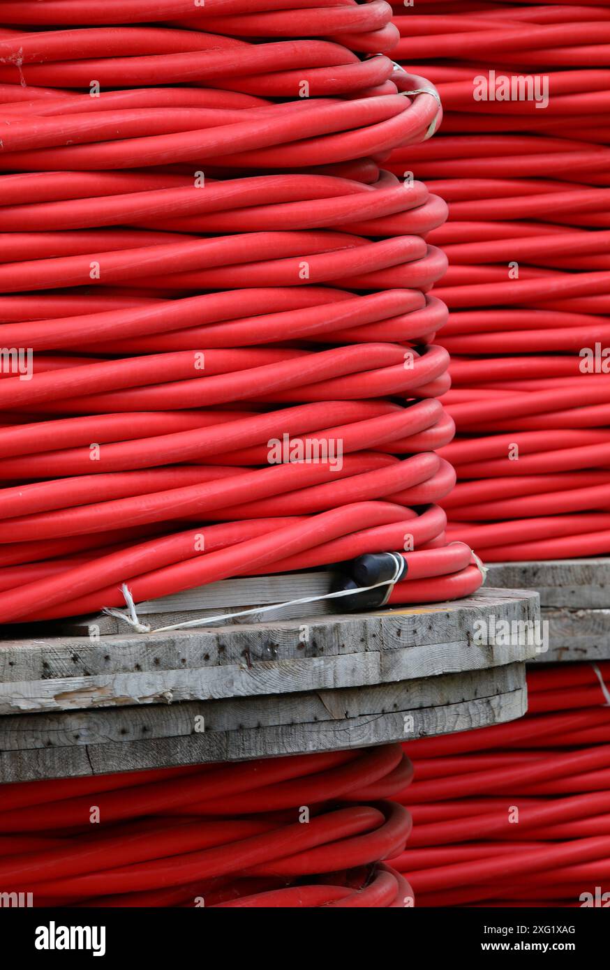 many coils Insulated high voltage red electric cable in the warehouse ...