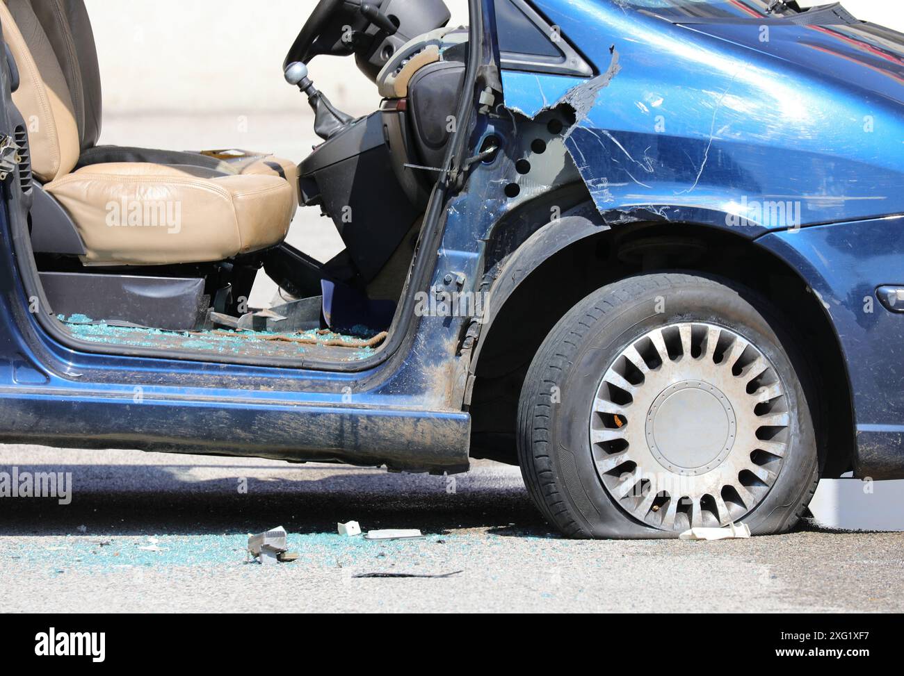 completely wrecked car with a flat tire and a torn-off door with ...