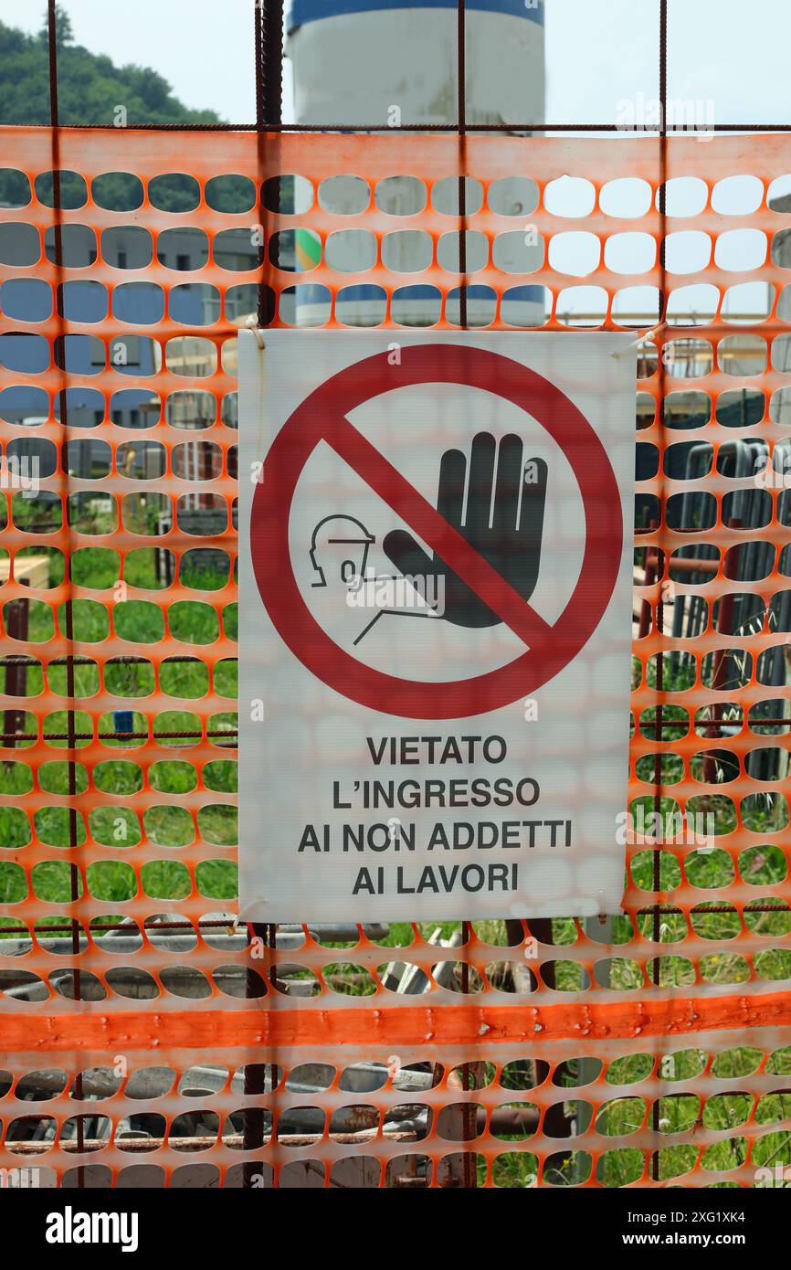 Construction site sign with italian text behind protective netting ...