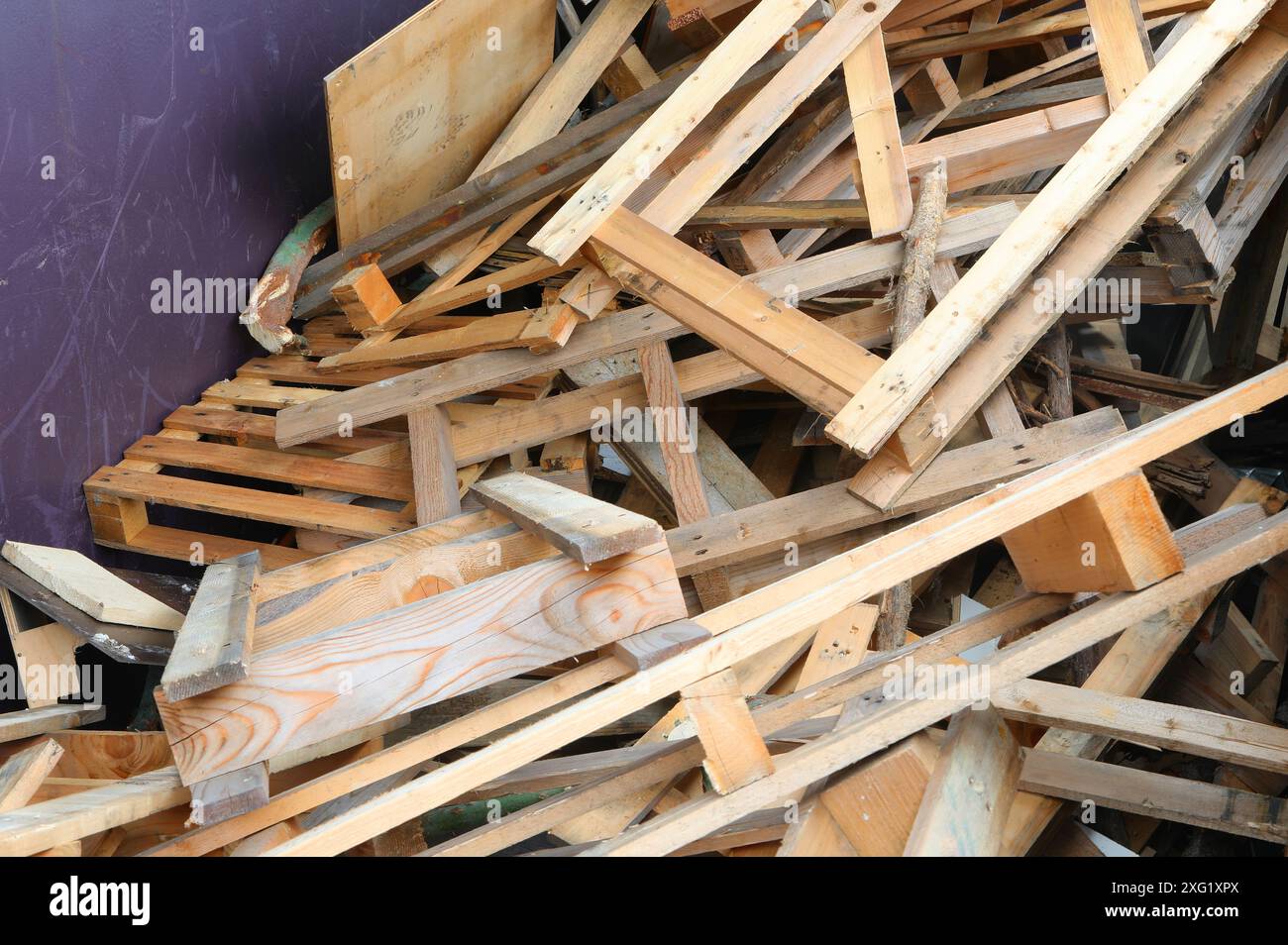 Used wooden planks and broken pallets in the wood recycling container ...
