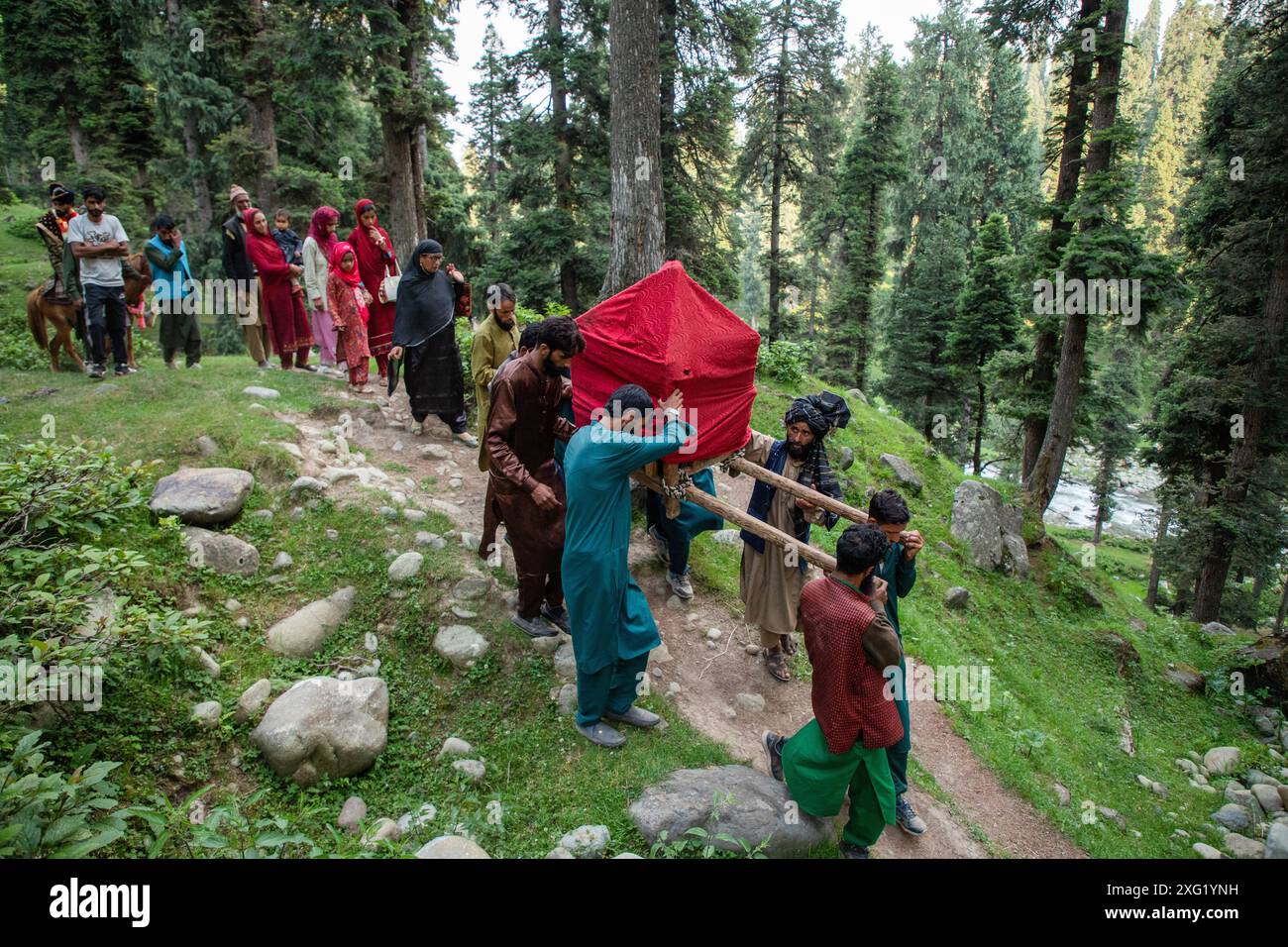 Gujjar (nomad) men carry a bride in the traditional palanquin as they walk towards the groom's ...