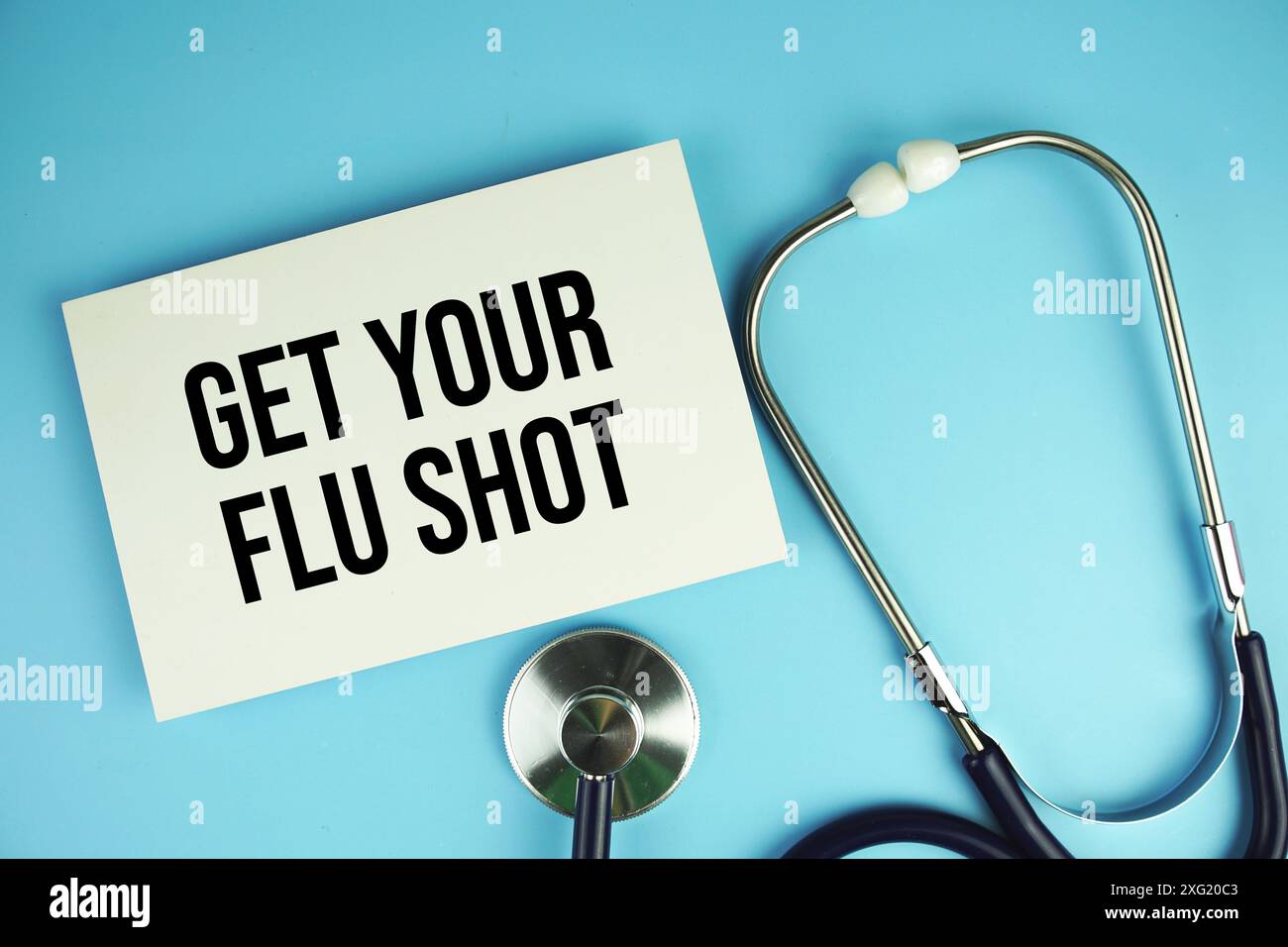 Get Your Flu Shot text on paper card with stethoscope top view on blue ...