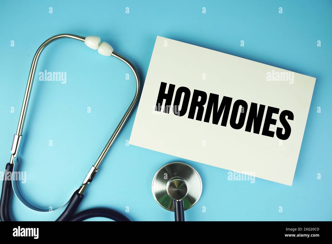 Hormones text on paper card with stethoscope top view on blue ...