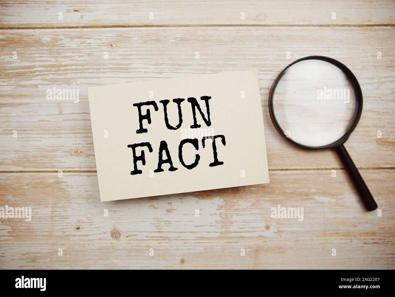 Fun Fact text message and magnifying glass with space copy on wooden ...