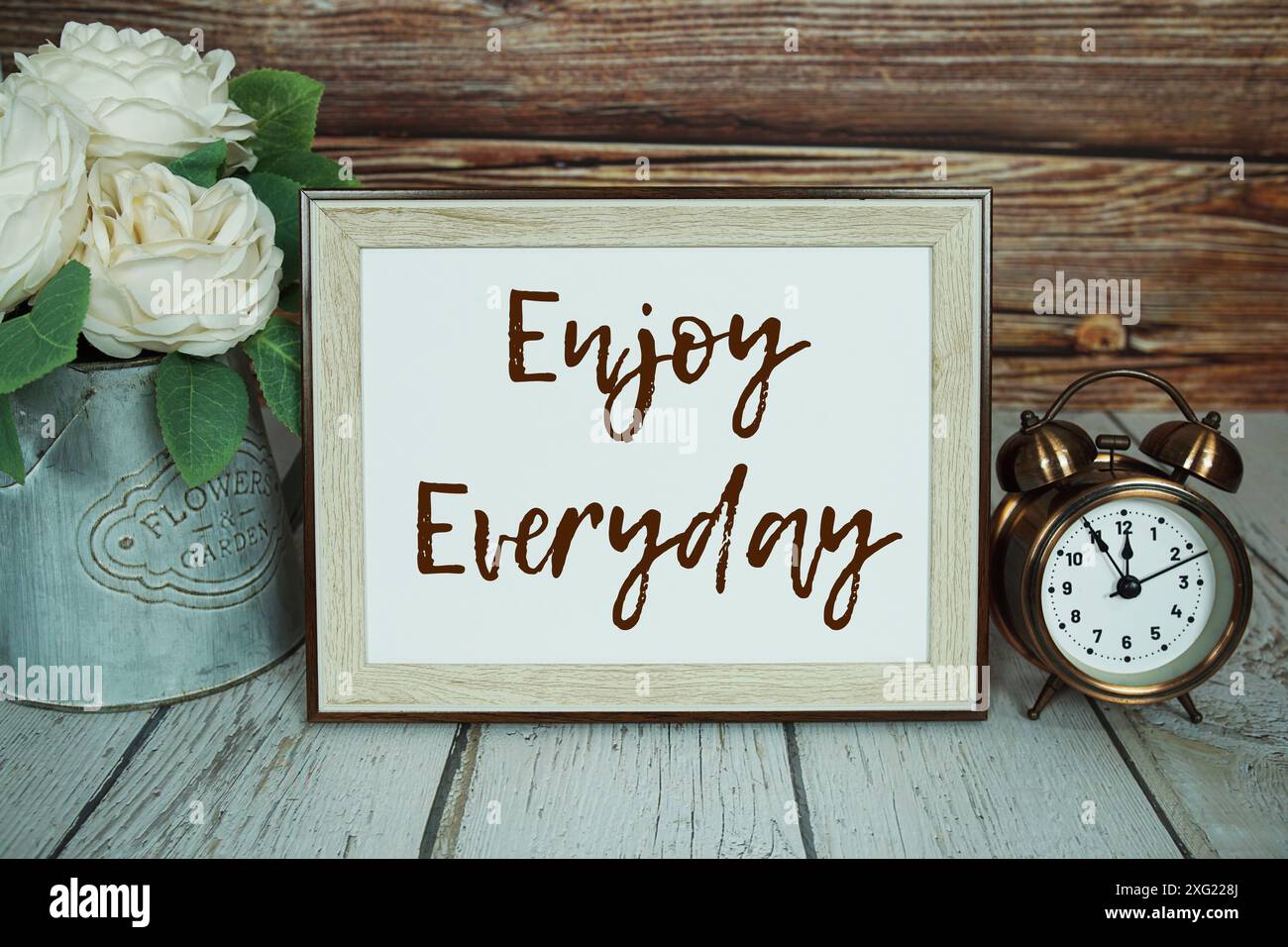 Enjoy Everyday text message with alarm clock on wooden background ...